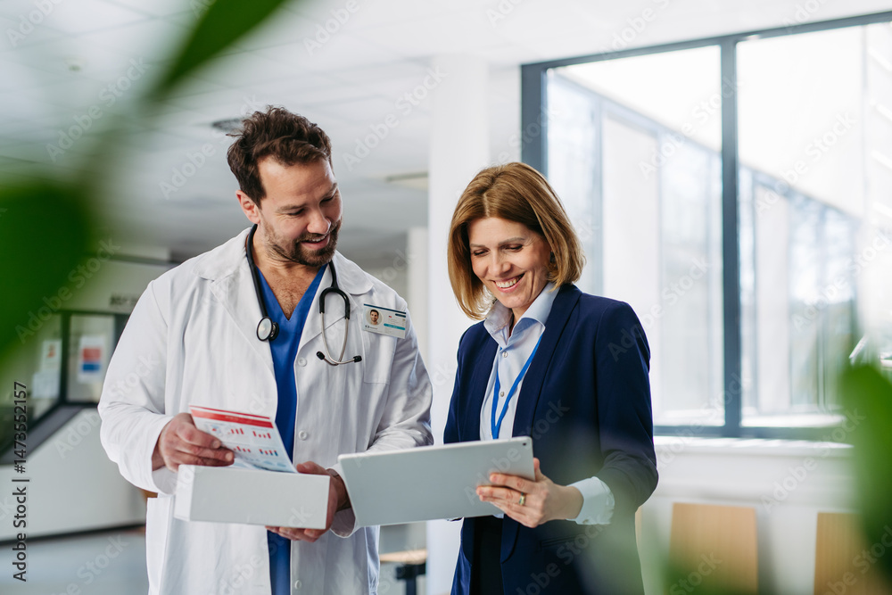 Female medical sales representative presenting medication to doctor ...