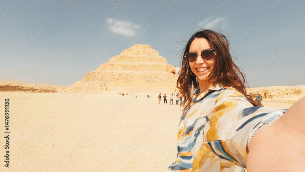 Tourist taking selfie with the step pyramid of djoser in saqqara, egypt ...