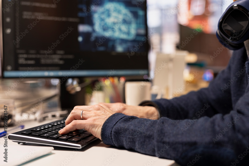 Software engineer in startup company office using computer to oversee ...