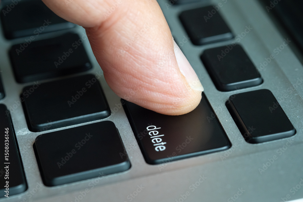 Finger of the computer user, he presses the delete button on the ...
