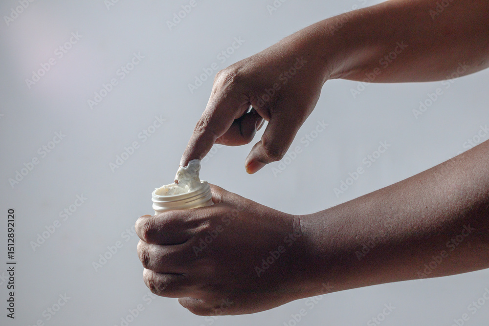 Finger dipping into creamy skincare jar showing soft texture and ...