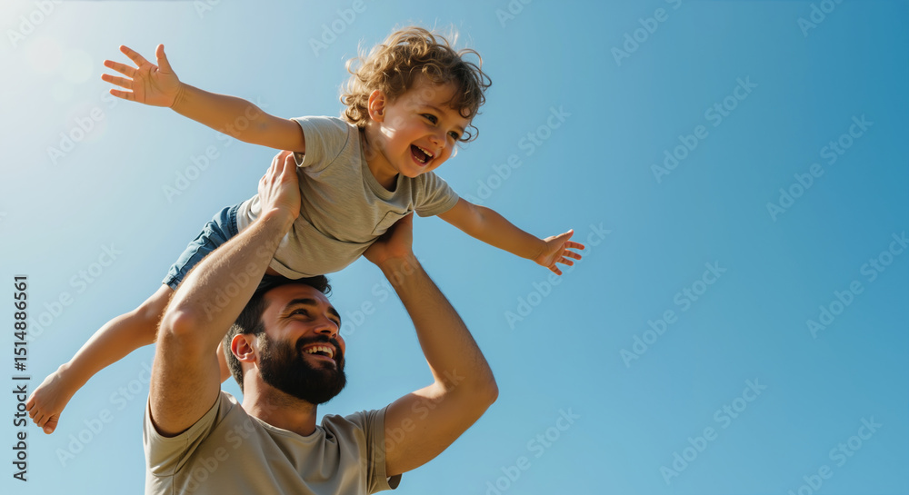 Happy bearded father lifting curly haired toddler son with arms spread ...