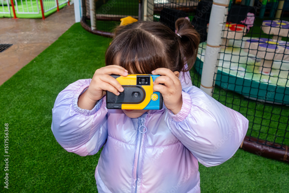 Little girl taking pictures with disposable camera in playground Stock ...