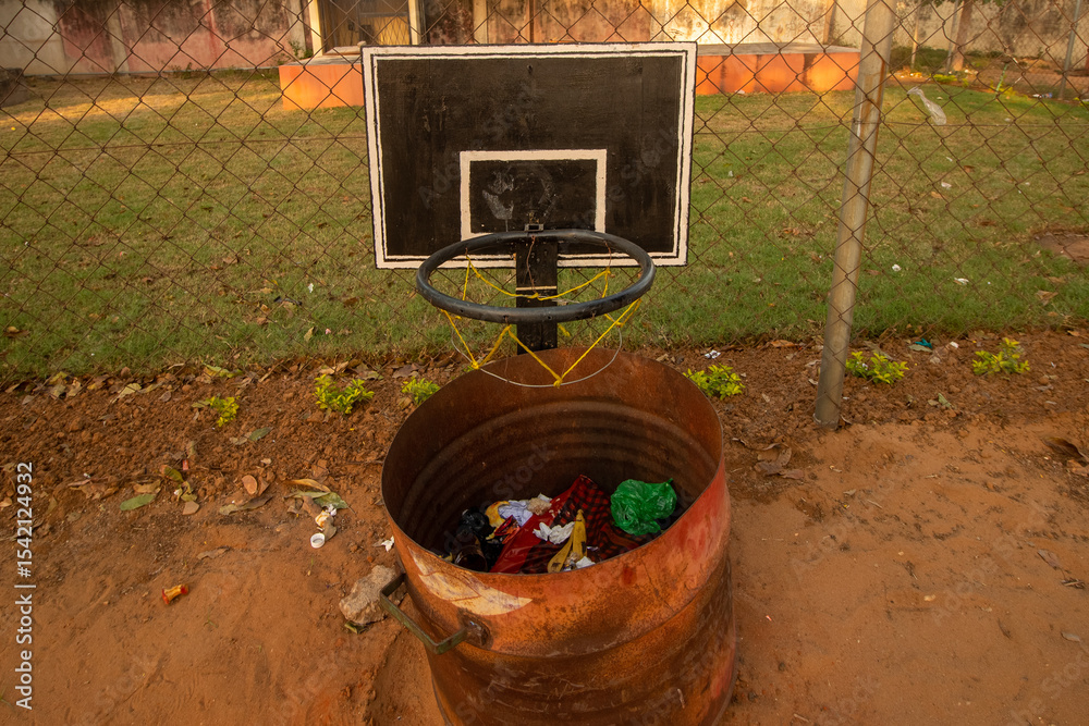 Rusty Recycle Bin with Makeshift Basketball Backboard on Dirt Ground ...