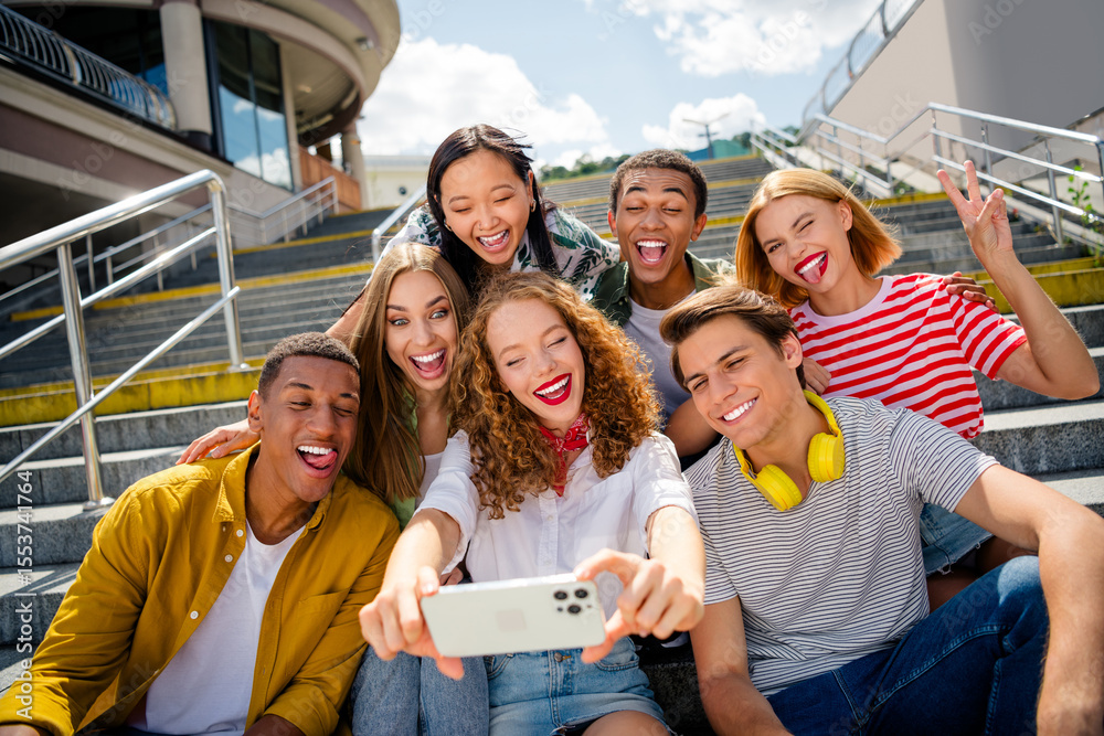 Group of happy friends taking a selfie outdoors in a sunny urban ...