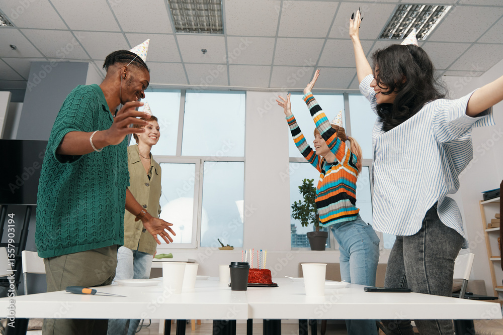 Young adult coworkers celebrating birthday in bright workplace, smiling ...