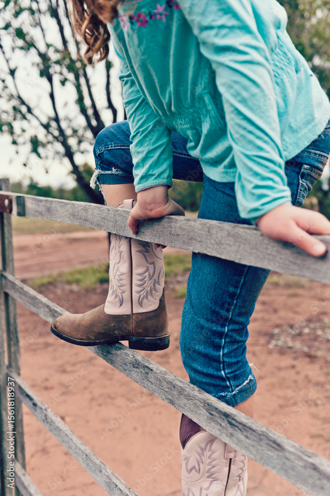 Tween girl climbing a timber fence on a rural property Stock Photo ...