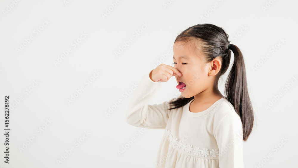Asian young child unhappy what smell disgust expression squeezing nose ...
