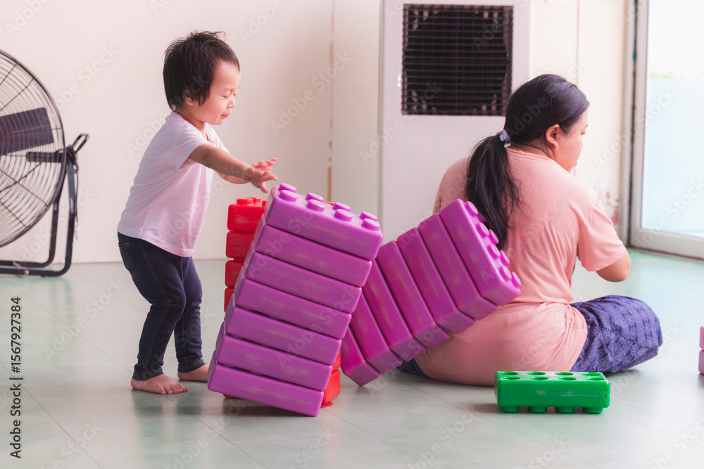 Mother and son enjoying playtime with building blocks. A two-year-old ...