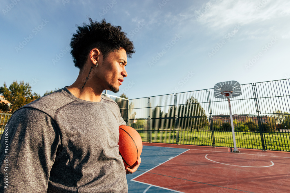 Outdoor basketball player holding ball on sunny day Stock Photo | Adobe ...