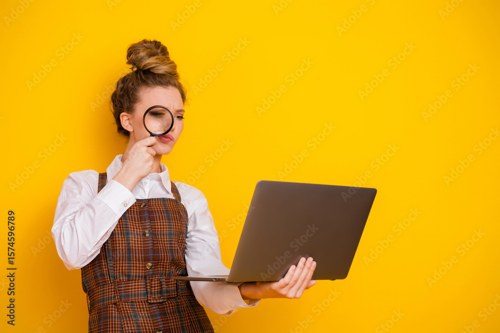 Stock-Foto „Young woman in stylish attire inspecting laptop closely ...
