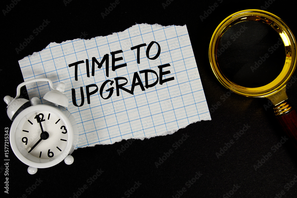Time To Upgrade text written on paper with magnifying glass and alarm ...