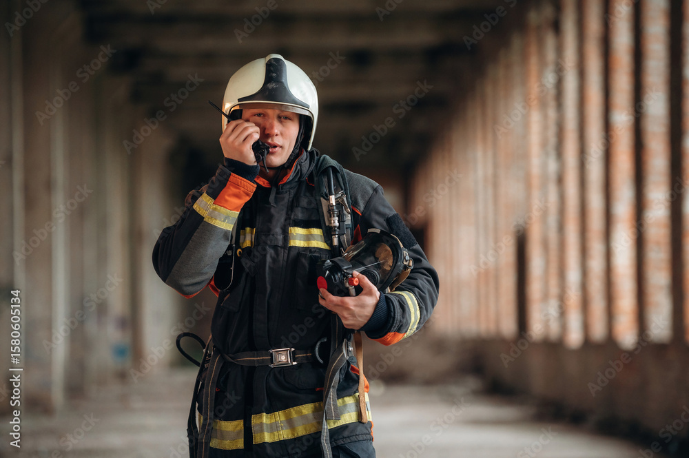 With walkie talkie radio. Firefighter in professional equipment is ...