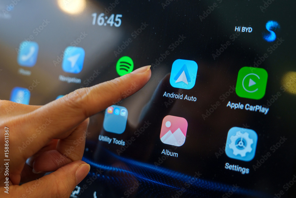 Penang, Malaysia - June 14, 2025: Close-up view of a finger selecting the Android Auto app on a ...