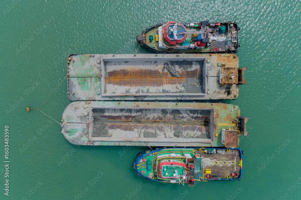 Aerial top-down view of two barges loaded with dredged material and ...