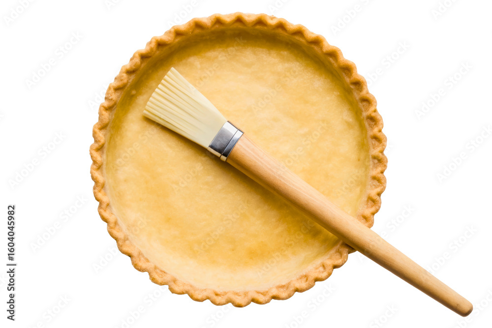 Empty pie crust in fluted pan with silicone pastry brush on top ...