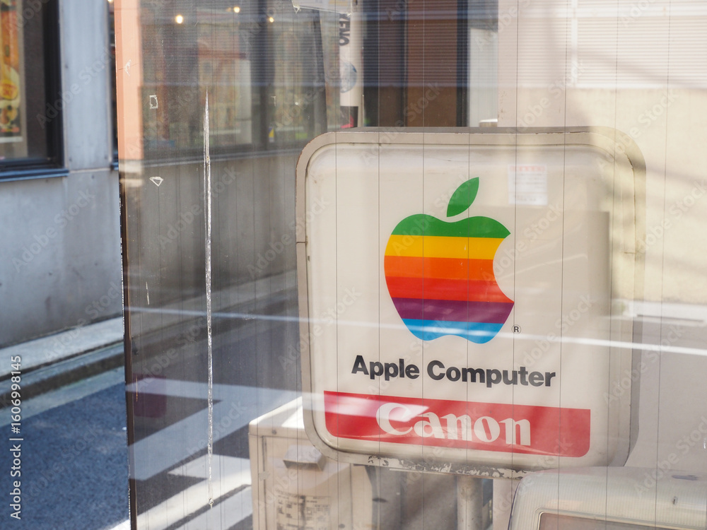 TOKYO, JAPAN - July 24, 2025: A sign featuring an old Apple logo and a ...