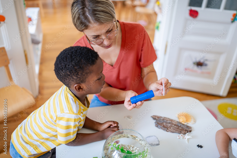 Preschool teacher guiding diverse children in science activities ...