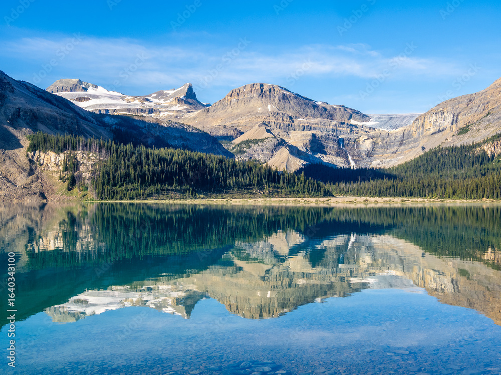 Crystal clear Bow Lake reflecting rugged mountains in Banff National ...