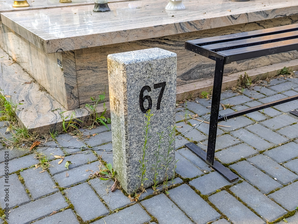 Warsaw, Poland, June 16, 2025 Stone grave marker numbered 67 stands ...