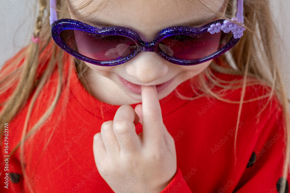 Little girl in purple heart sunglasses, nervous nail biting habit ...