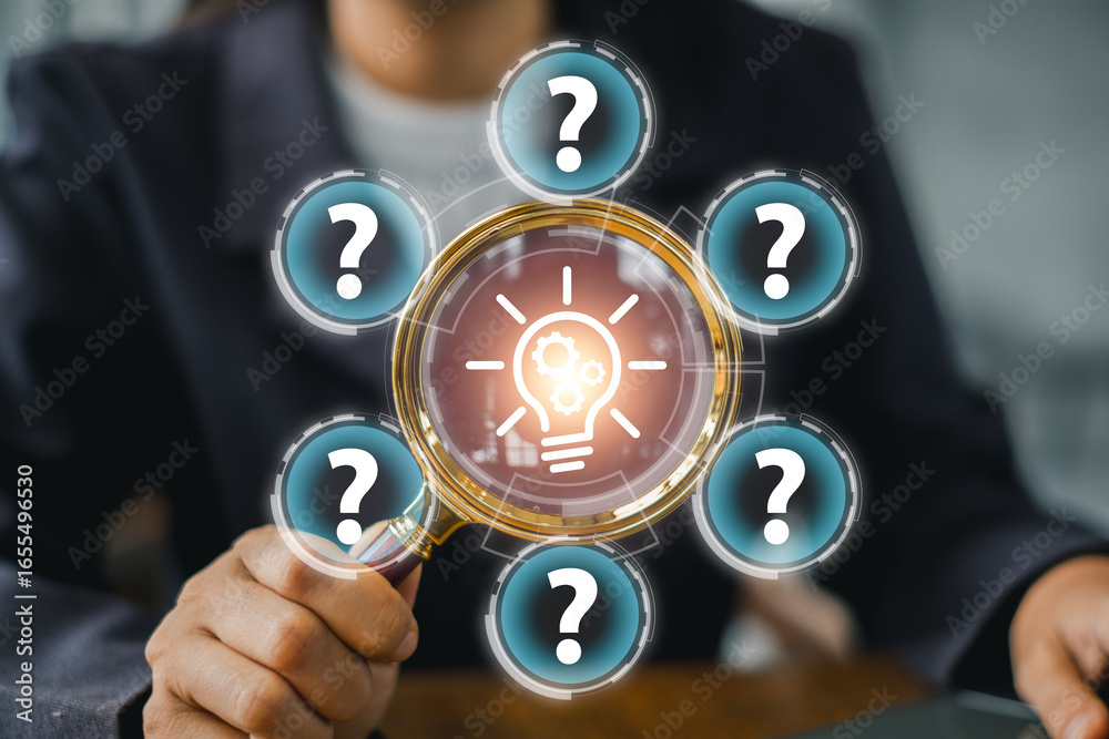 A business professional uses a magnifying glass to explore ideas ...