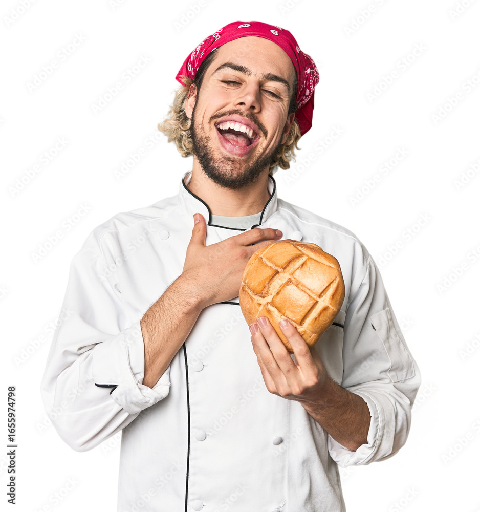 Young chef with artisan bread in studio laughs out loudly keeping hand ...