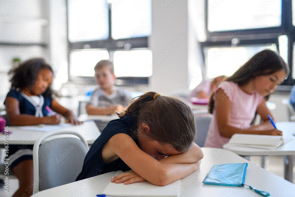 Exhausted child struggling with schoolwork at school. Stock Photo ...