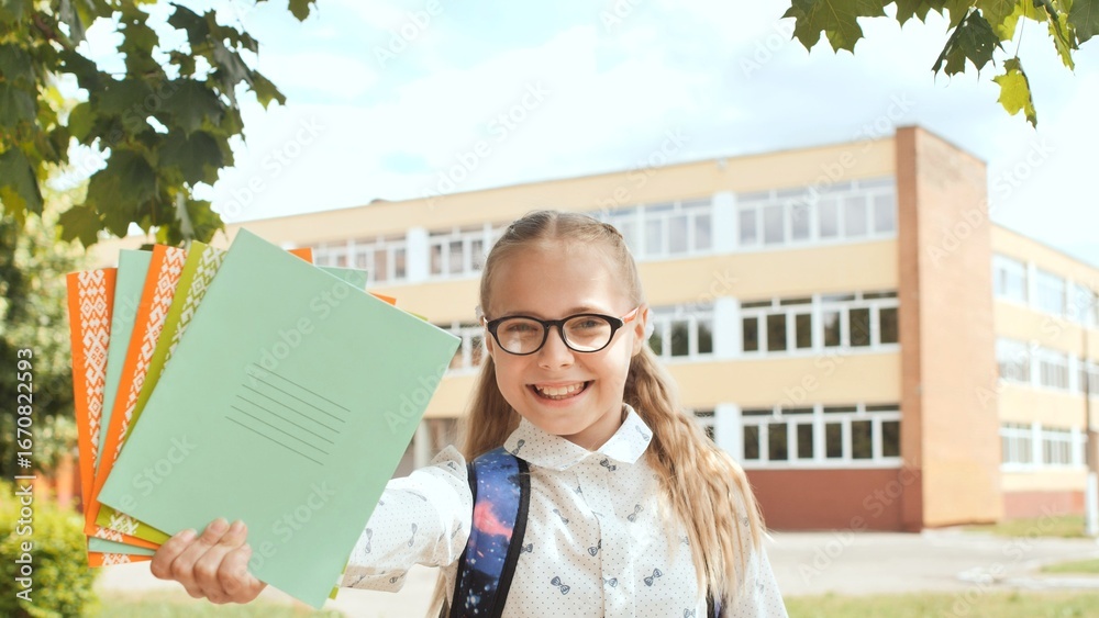 Portrait of a smiling schoolgirl showing notebooks and rulers. Happy ...