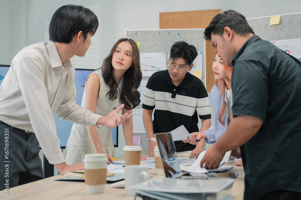 During an agile hackathon, a closeup of hands shows a team using data ...