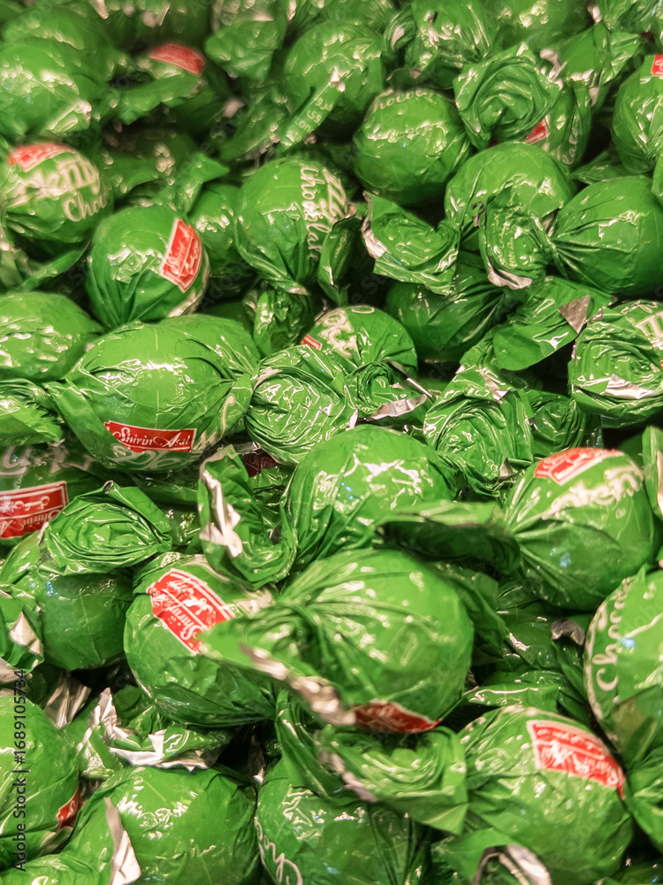 Green candy packets stacked together in bulk for sale. Photographed on ...