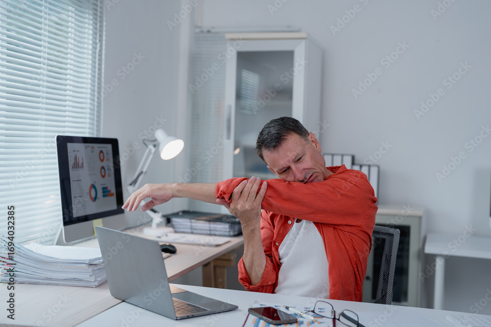 Office worker suffering from elbow pain while working on laptop ...
