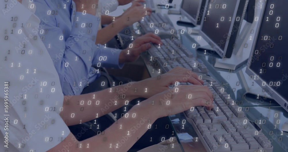 Typing office workers entering program commands at long office desk ...