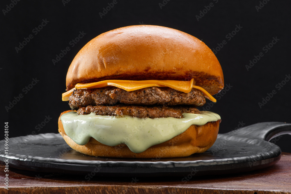 Beef hamburger, melted cheddar cheese, mayonnaise, on a hamburger bun ...