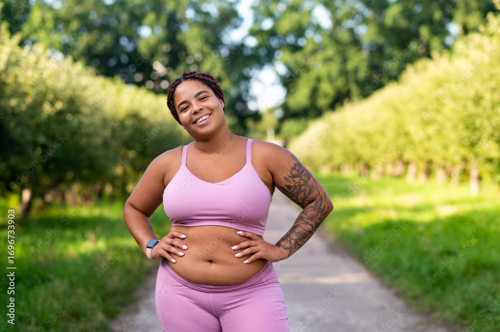 Smiling natural plus size woman in workout clothing outdoors Stock ...