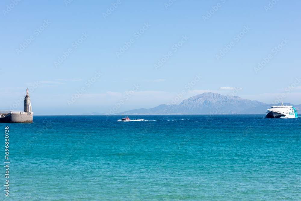 View of Gibraltar Strait with lighthouse, ferry, and Morocco. Tarifa ...