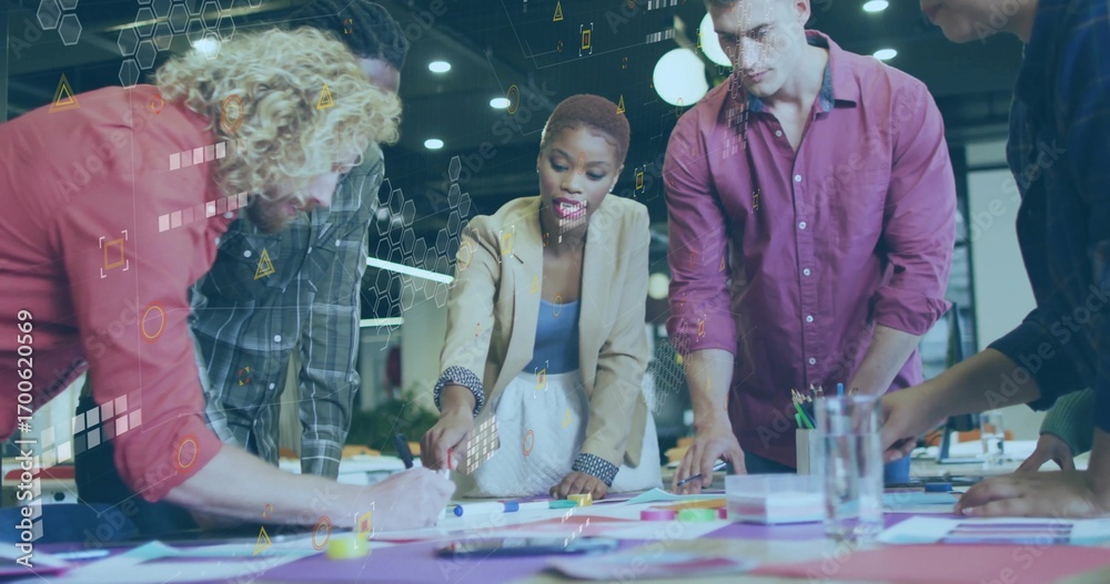 Brainstorming group of five professionals leaning over office table ...
