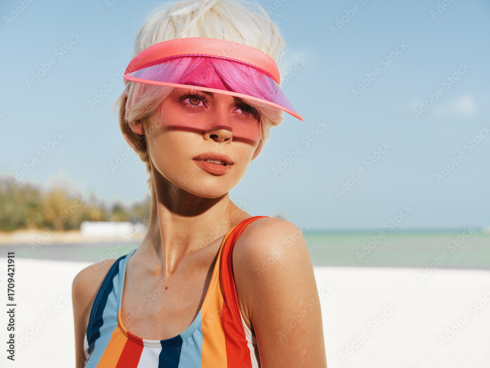 A stylish beach portrait featuring a sunlit woman in a colorful striped ...