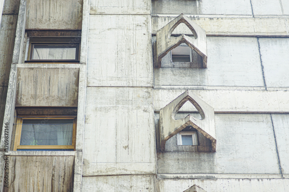Raw concrete façade with angular brutalist windows. Close-up of the ...