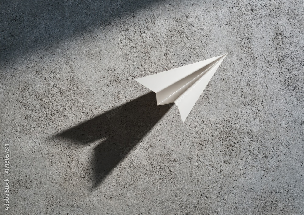 Paper Airplane on Concrete Surface with Shadow. Stock Photo | Adobe Stock
