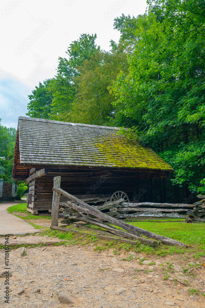 Small cantilever barn with moss on the roof and a split rail fence on ...