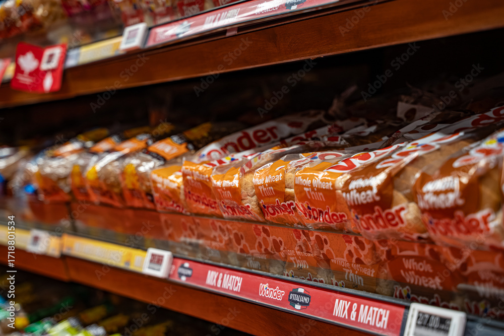 Shelf with packaged bread loaves displayed in supermarket bakery ...