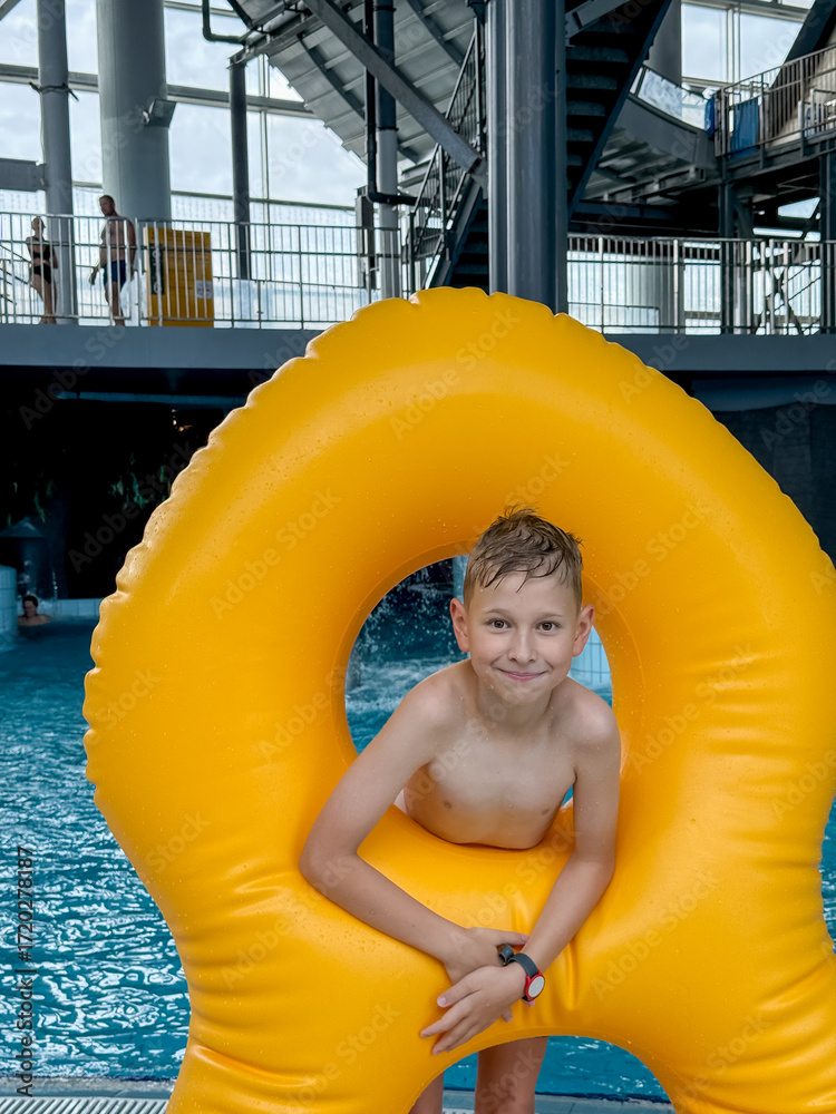 Teen boy with giant inflatable float in indoor water park Stock Photo ...