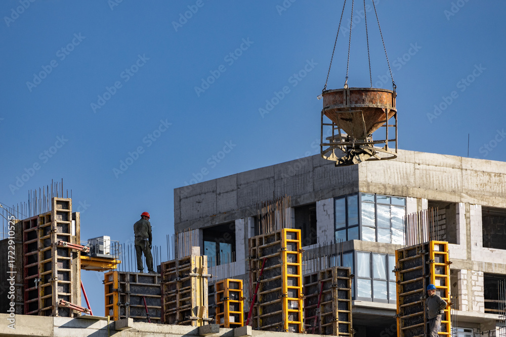 Cast-in-place concrete. Crane lifting concrete container on ...