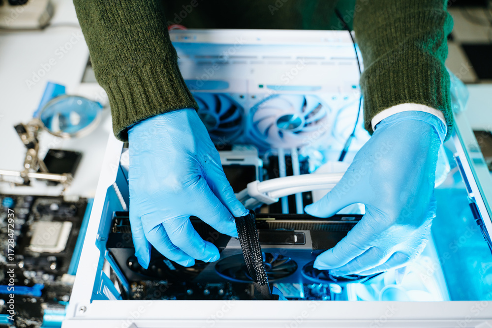 Technician installing GPU in custom PC build wearing gloves. Concept of ...
