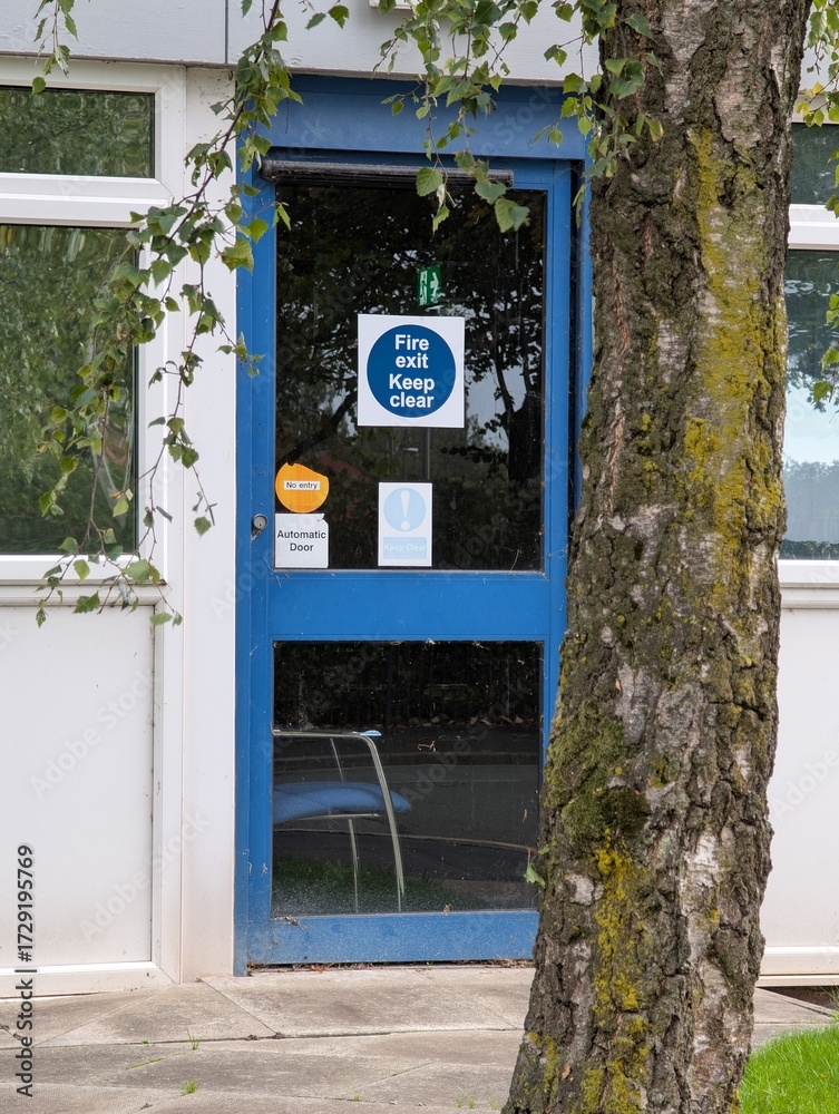 Stock-Foto „Blue office exterior door marked with a fire exit sign that ...