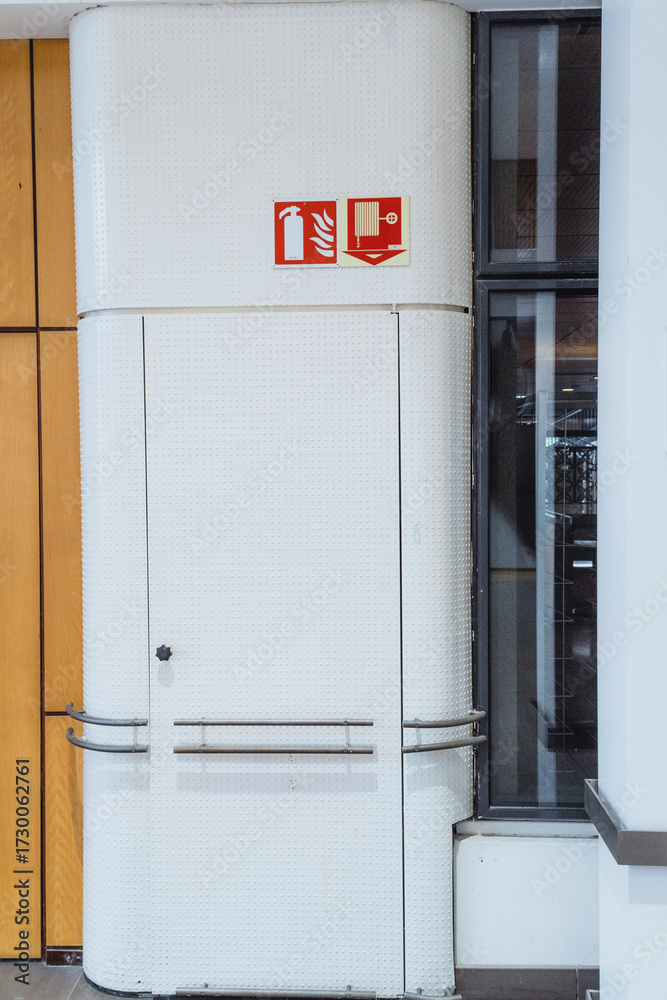Fire safety cabinet with extinguisher and hose symbols on wall ...