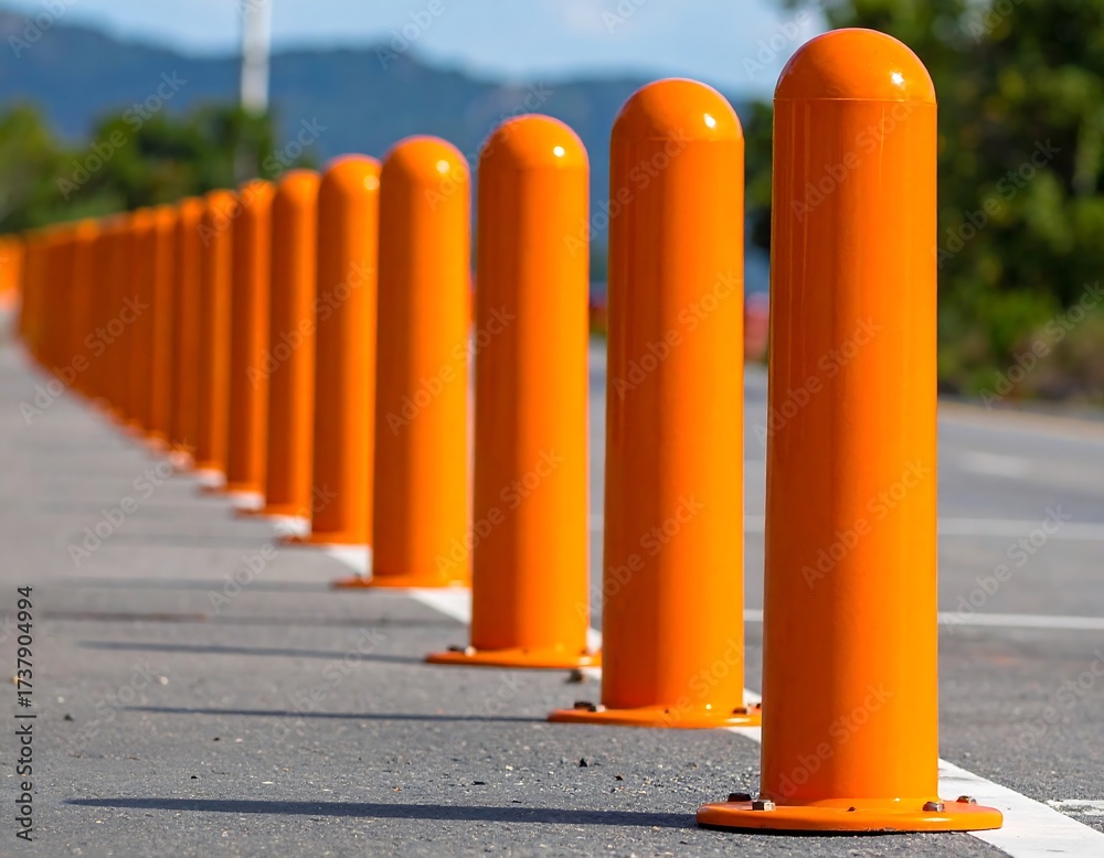 Stockfotot Orange Traffic Bollards on a Road. | Adobe Stock