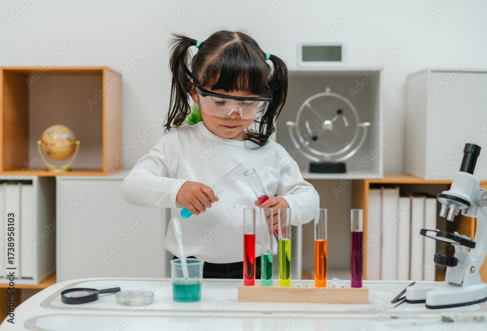 toddler girl scientist making chemical test with test tube and beaker ...