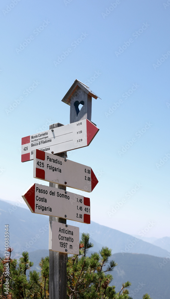 Trail marker with directional arrows and mountain names to follow the ...